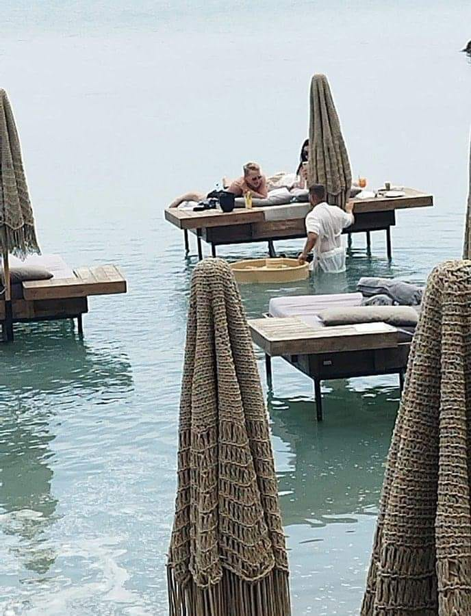 Service Rhodes style: Waiter wading above waist into the sea
